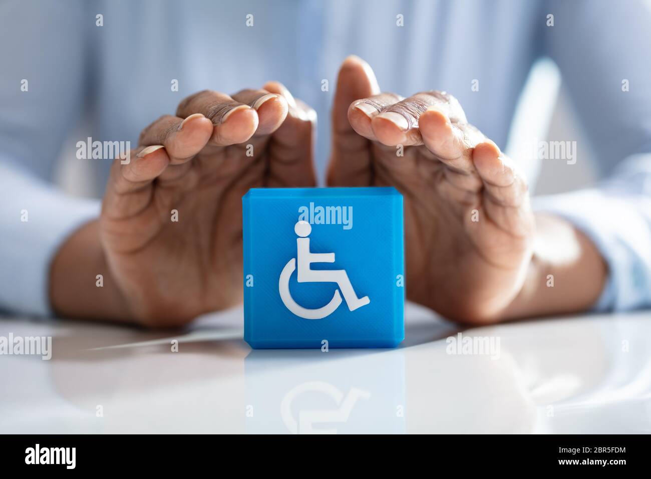 Close-up Of A Human's Hand Protecting Blue Cubic Block With Disabled ...