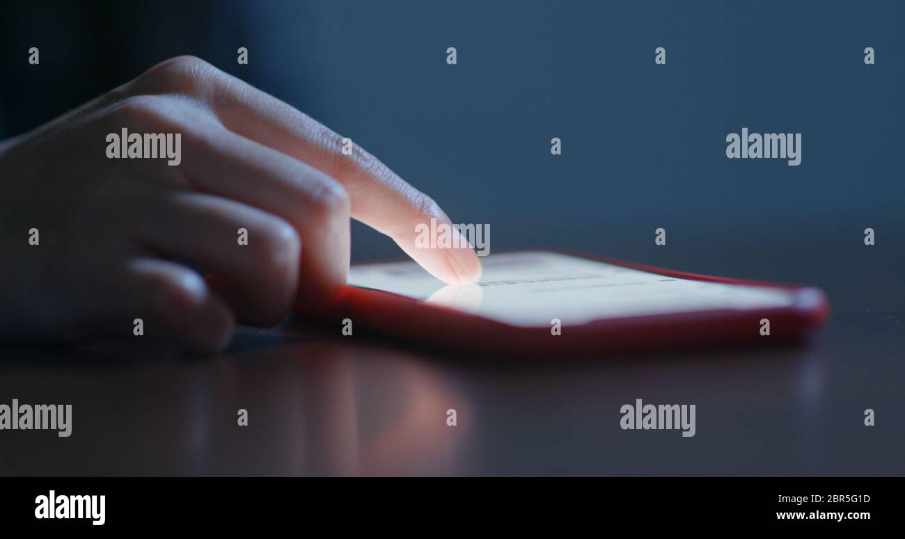 Finger touch on the screen of cellphone at night Stock Photo - Alamy