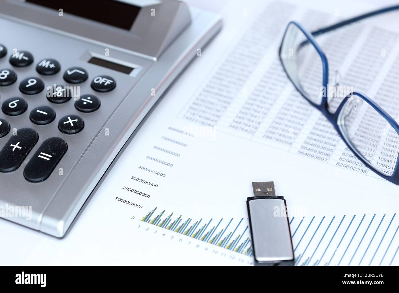 some charts with calculator and data-stick on desk Stock Photo - Alamy