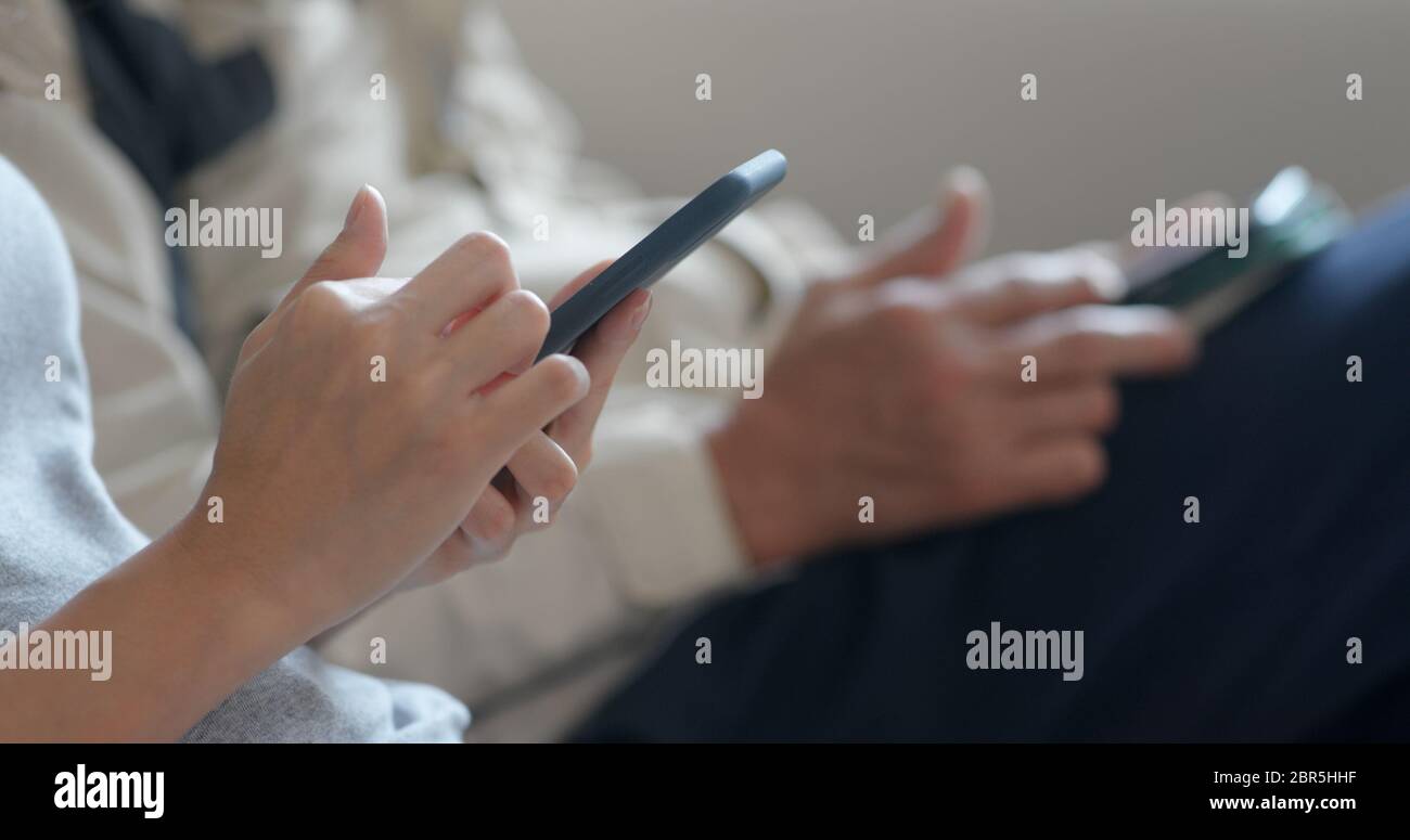 People use of mobile phone together at home Stock Photo - Alamy