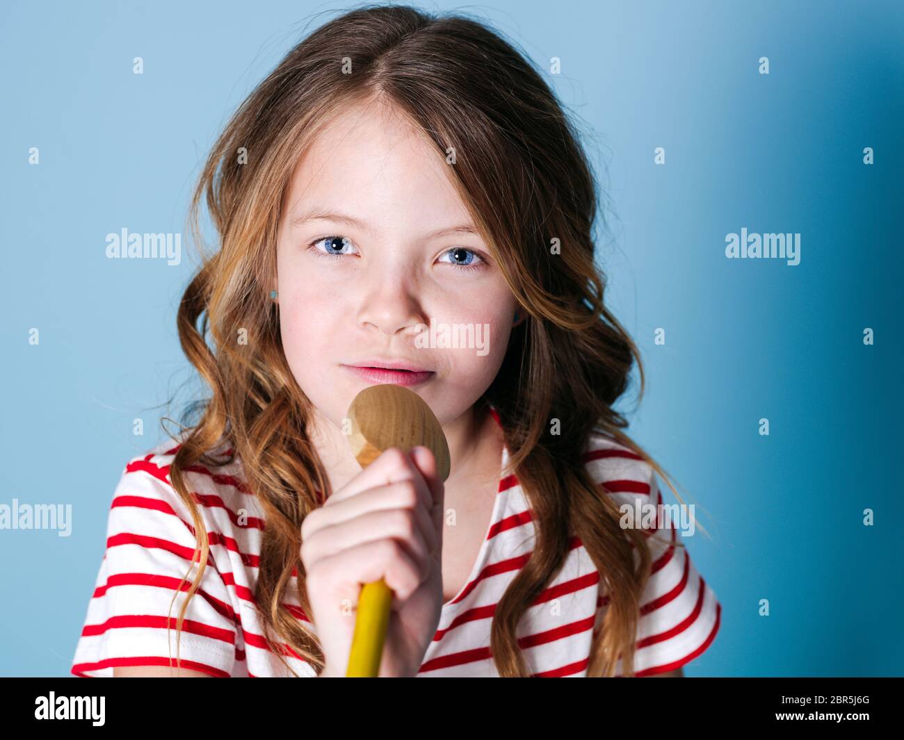pretty cool and young girl uses cooking spoon as microphone and sings ...