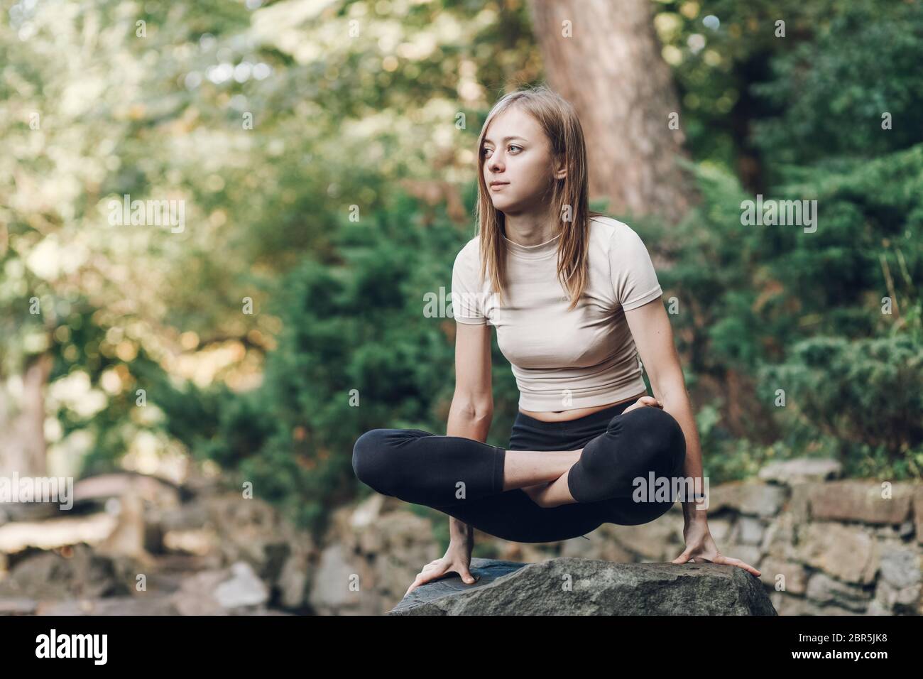 Yoga exercise outdoors. Scales lotus poses. Girl in lotus pose on the ...