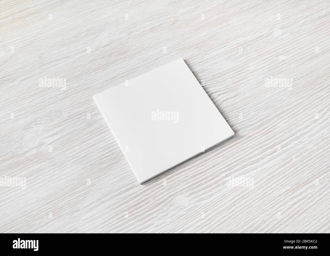 Blank square brochure on light wooden background. Responsive design ...