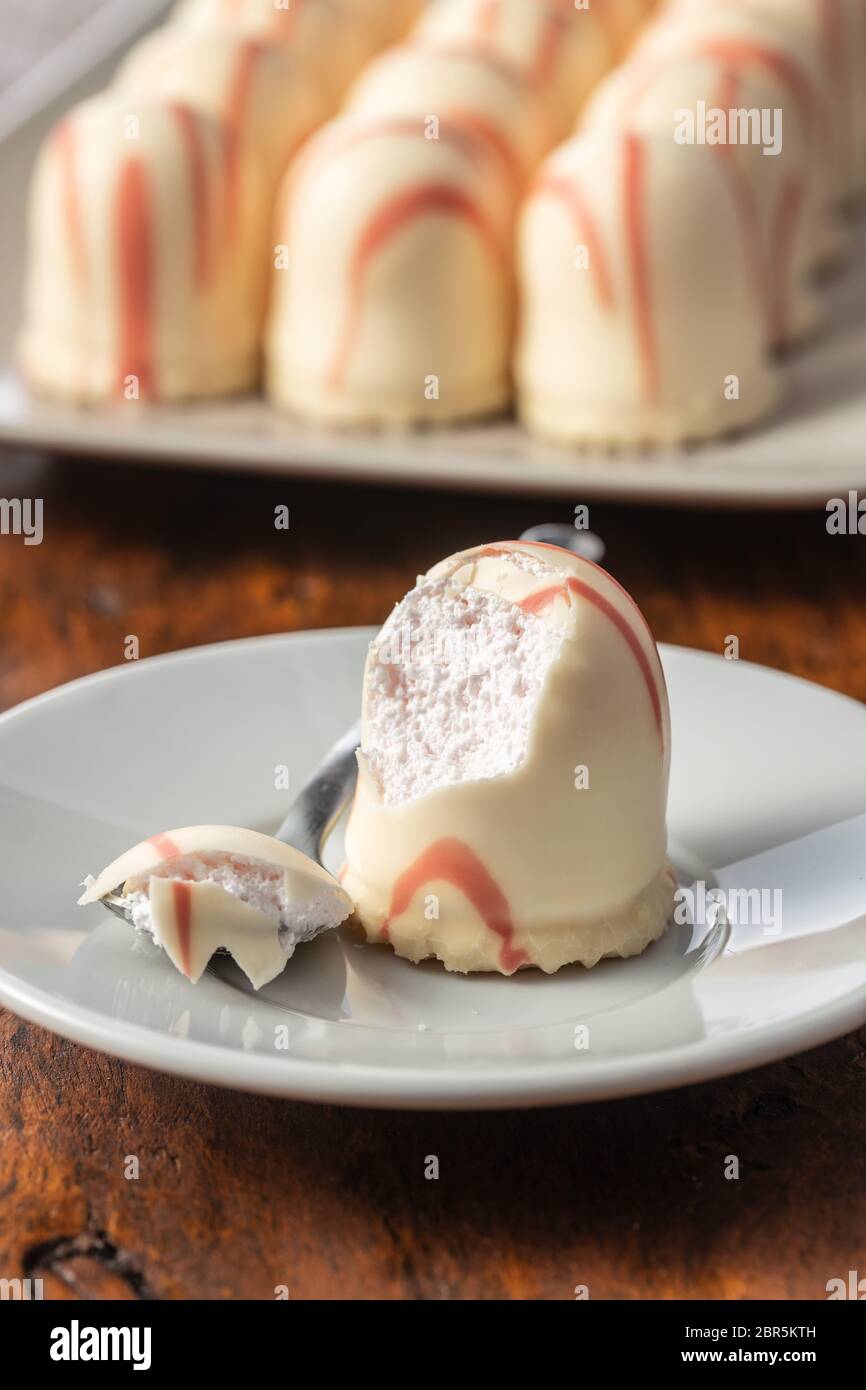 Sweet foam dessert. Biten marshmallow covered with strawberry icing on ...