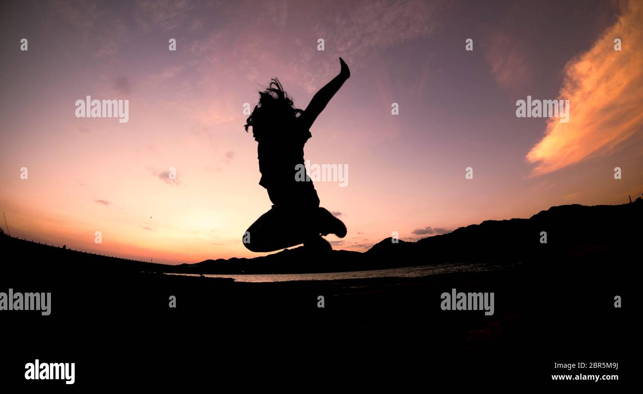 Silhouette, happy jumping Shadow girl Jump on the orange sky in the ...