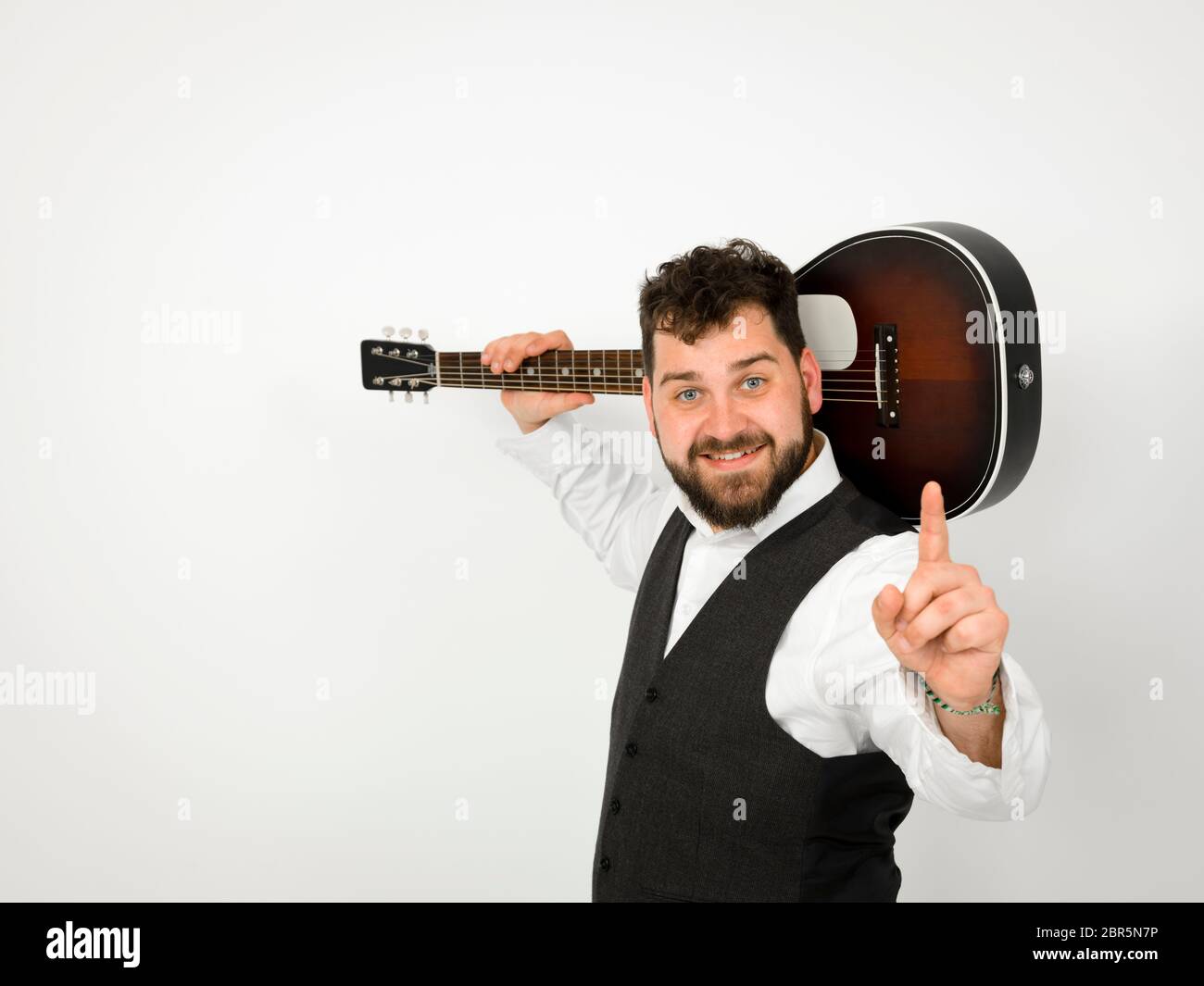 man with black hair and beard playing and singing with acoustic guitar ...