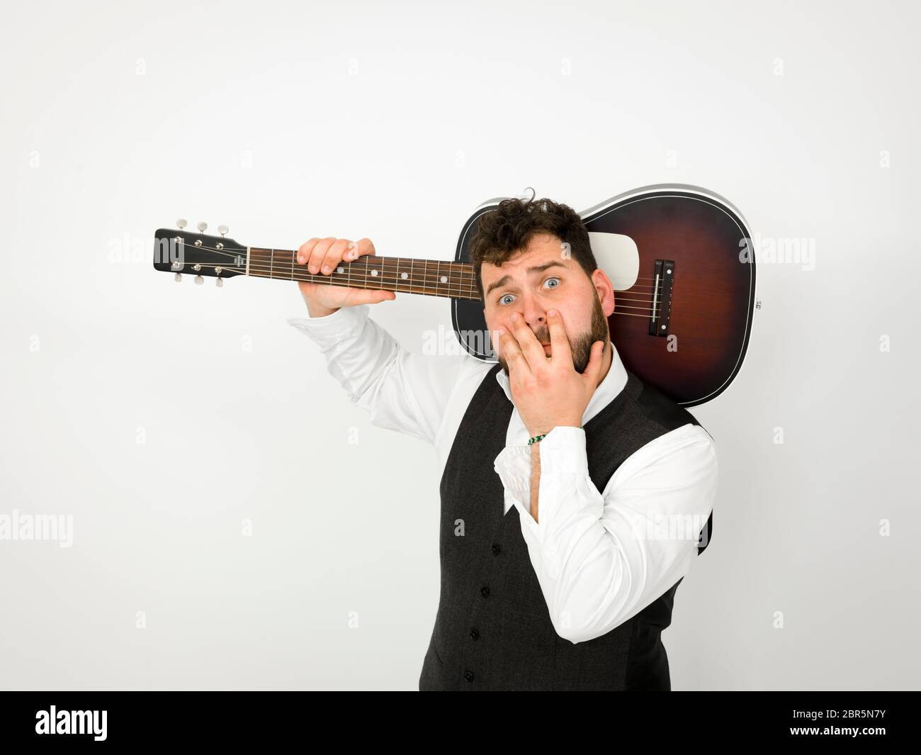 man with black hair and beard playing and singing with acoustic guitar ...