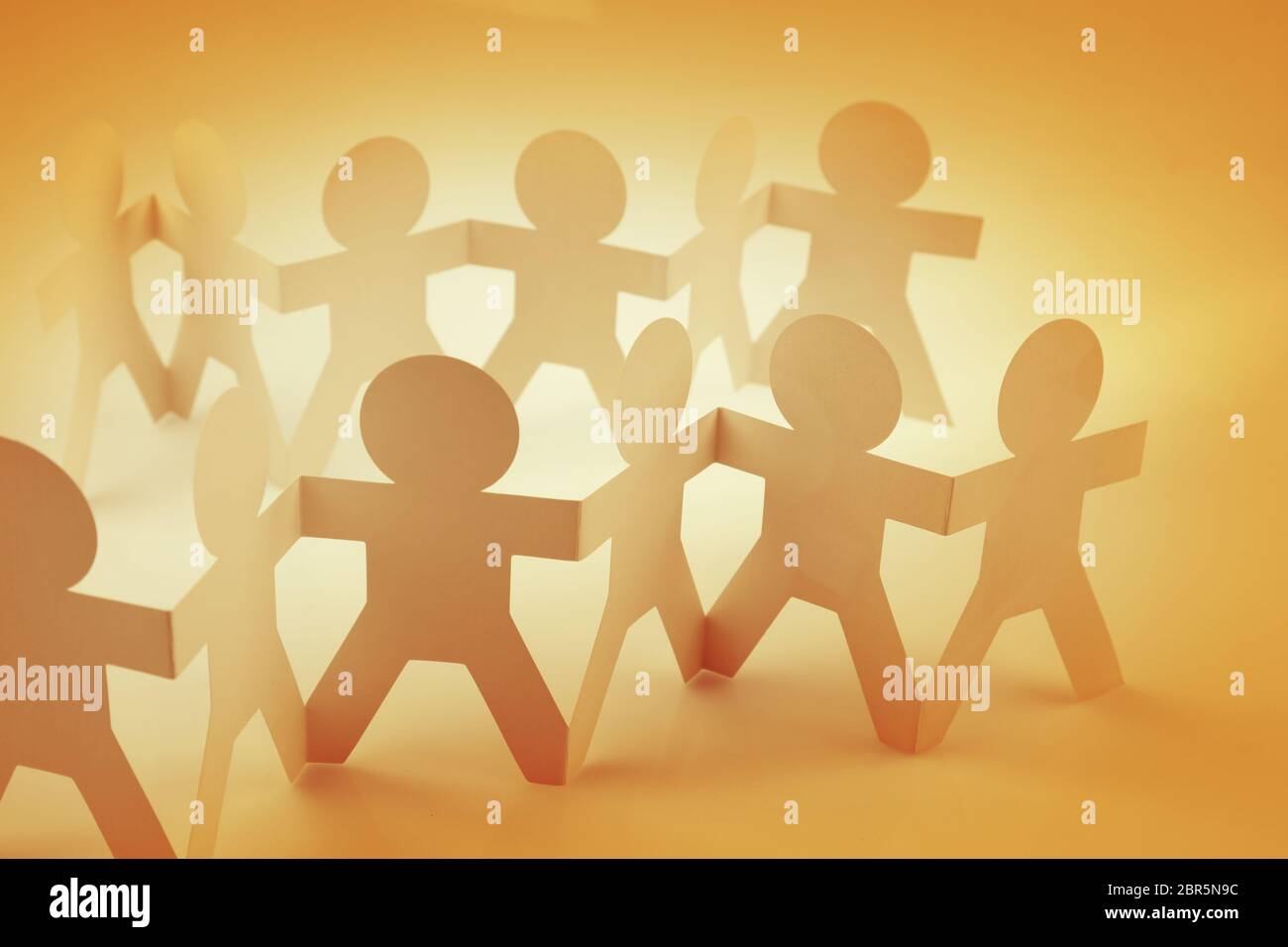 Paper chain team holding hands. Teamwork. Partnership Stock Photo - Alamy