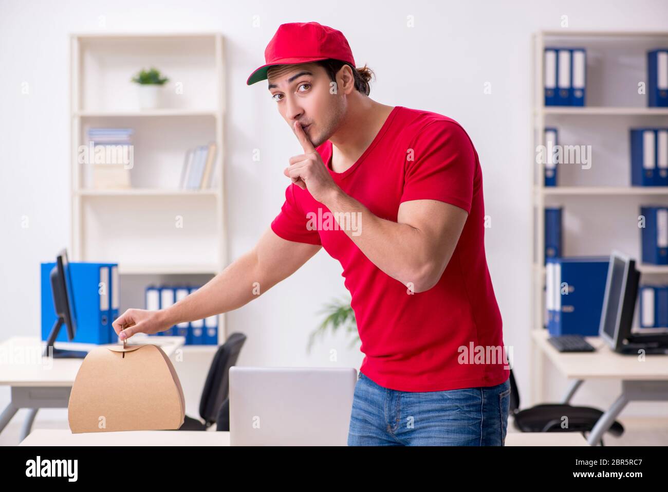 Young courier delivering cake to the office Stock Photo - Alamy