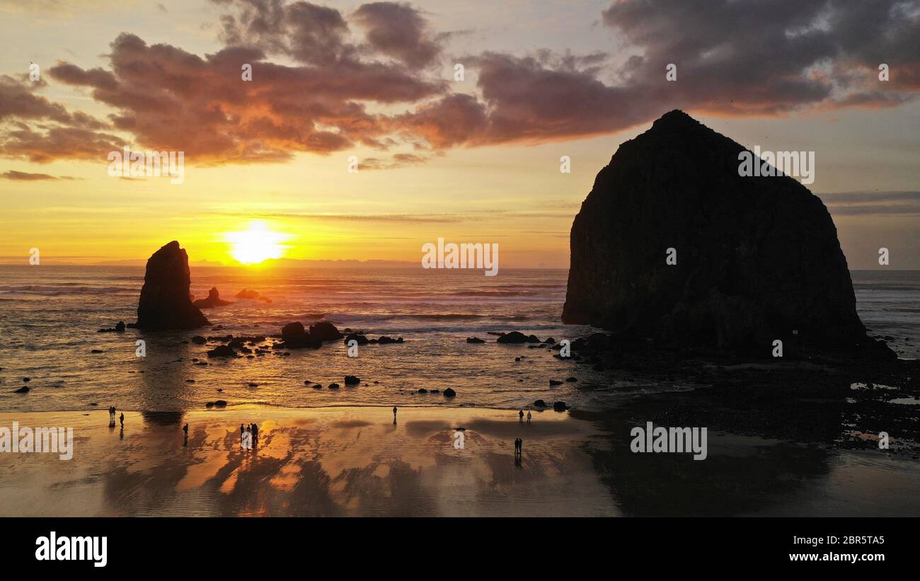 People walk on the beach reflection late afternoon at dusk in Cannon ...