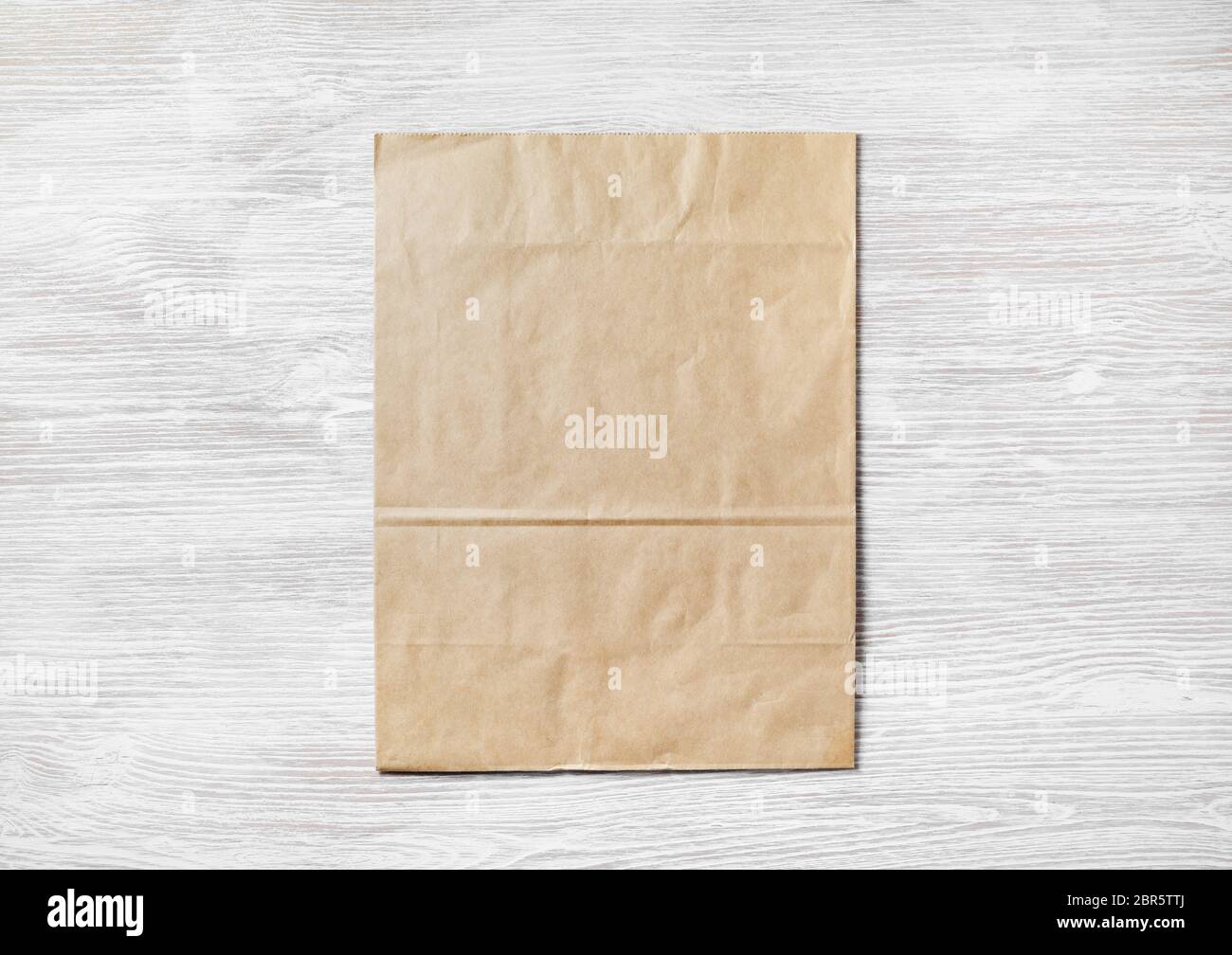 Crumpled kraft paper bag on light wooden background. Blank recyclable ...