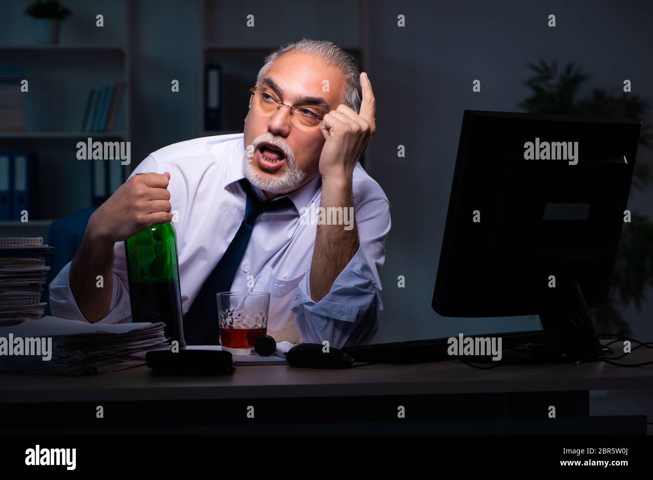 Old employee working late in the office Stock Photo - Alamy