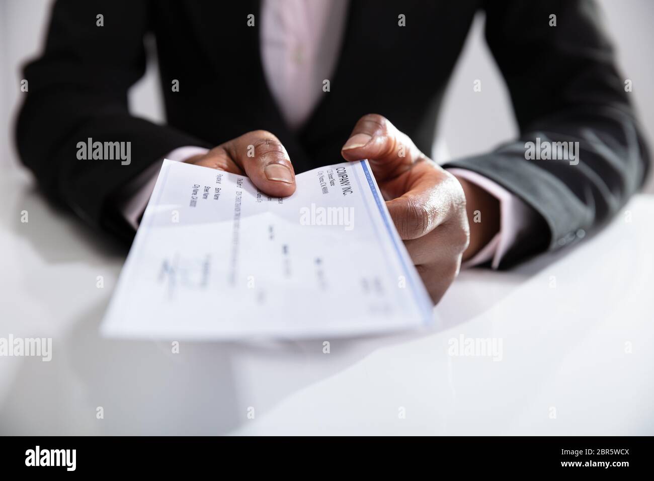 Photo Of Businesswoman Giving Cheque Over White Desk Stock Photo - Alamy