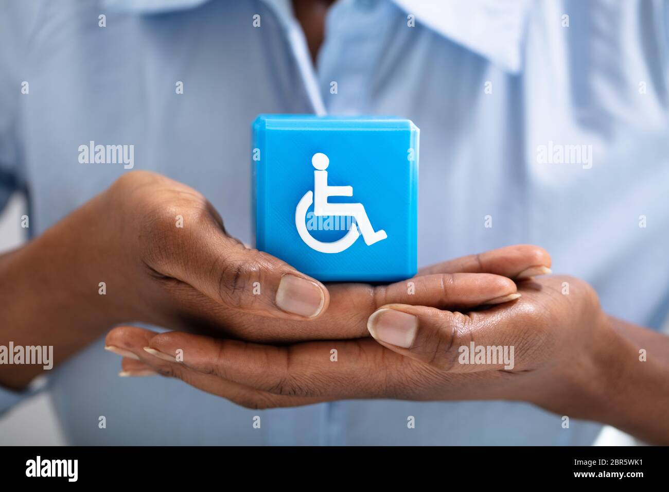 Close-up Of A Human's Hand Protecting Blue Cubic Block With Disabled ...