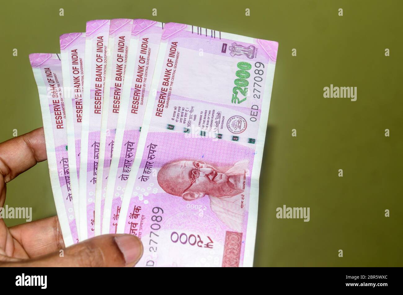Selective Focus: Hand holding Indian 2000 rupee notes against isolated ...