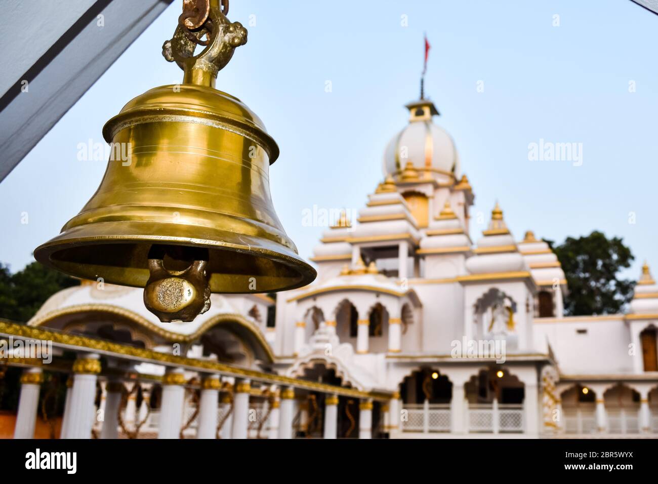 Ring bells in temple. Golden metal bell isolated. Big brass Buddhist ...