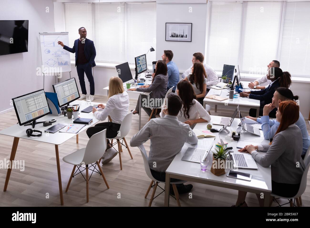 African Businessman Giving Presentation To His Colleagues Sitting On ...
