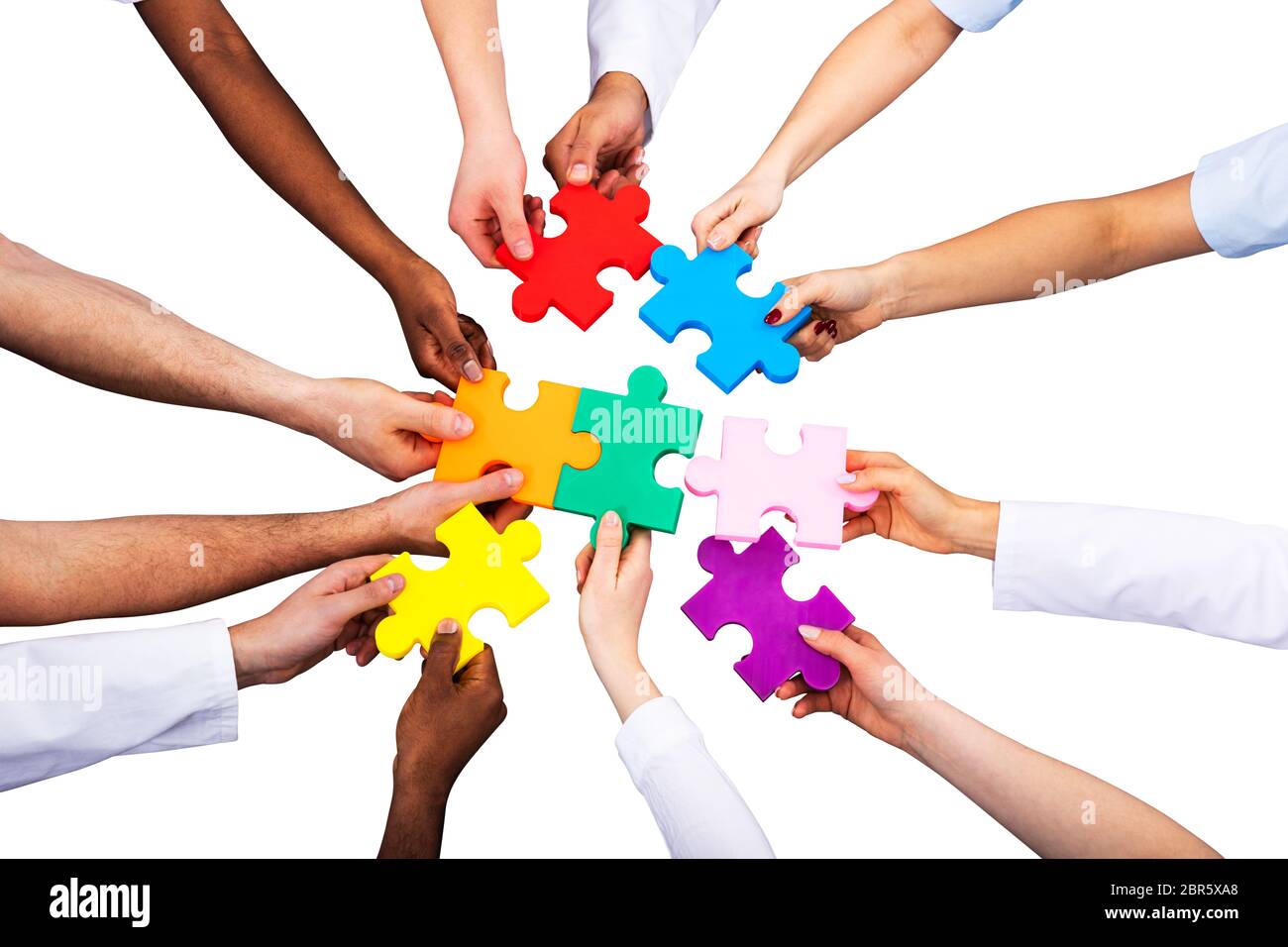 High Angle View Of Medical Team Solving Colorful Jigsaw Puzzle Against ...