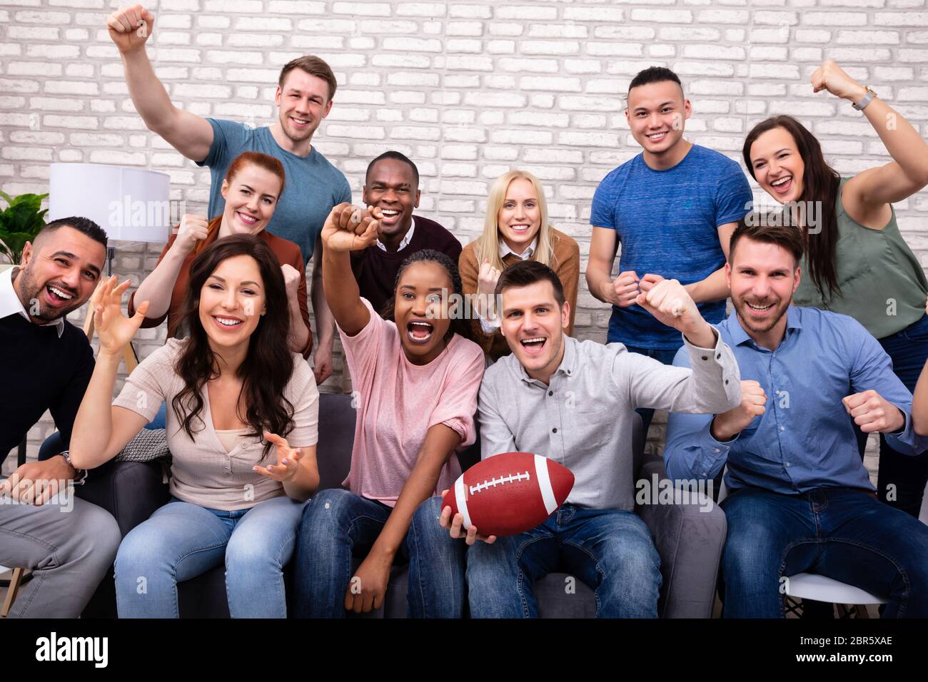 Young Friends Cheering While Watching Rugby Match At Home Stock Photo ...