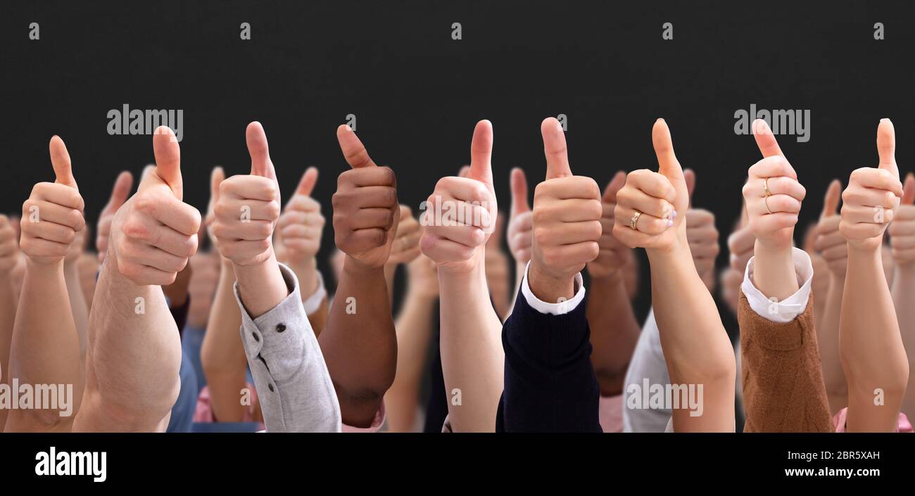 Close-up Of People's Hand Showing Thumb Up Sign Over Black Backdrop ...
