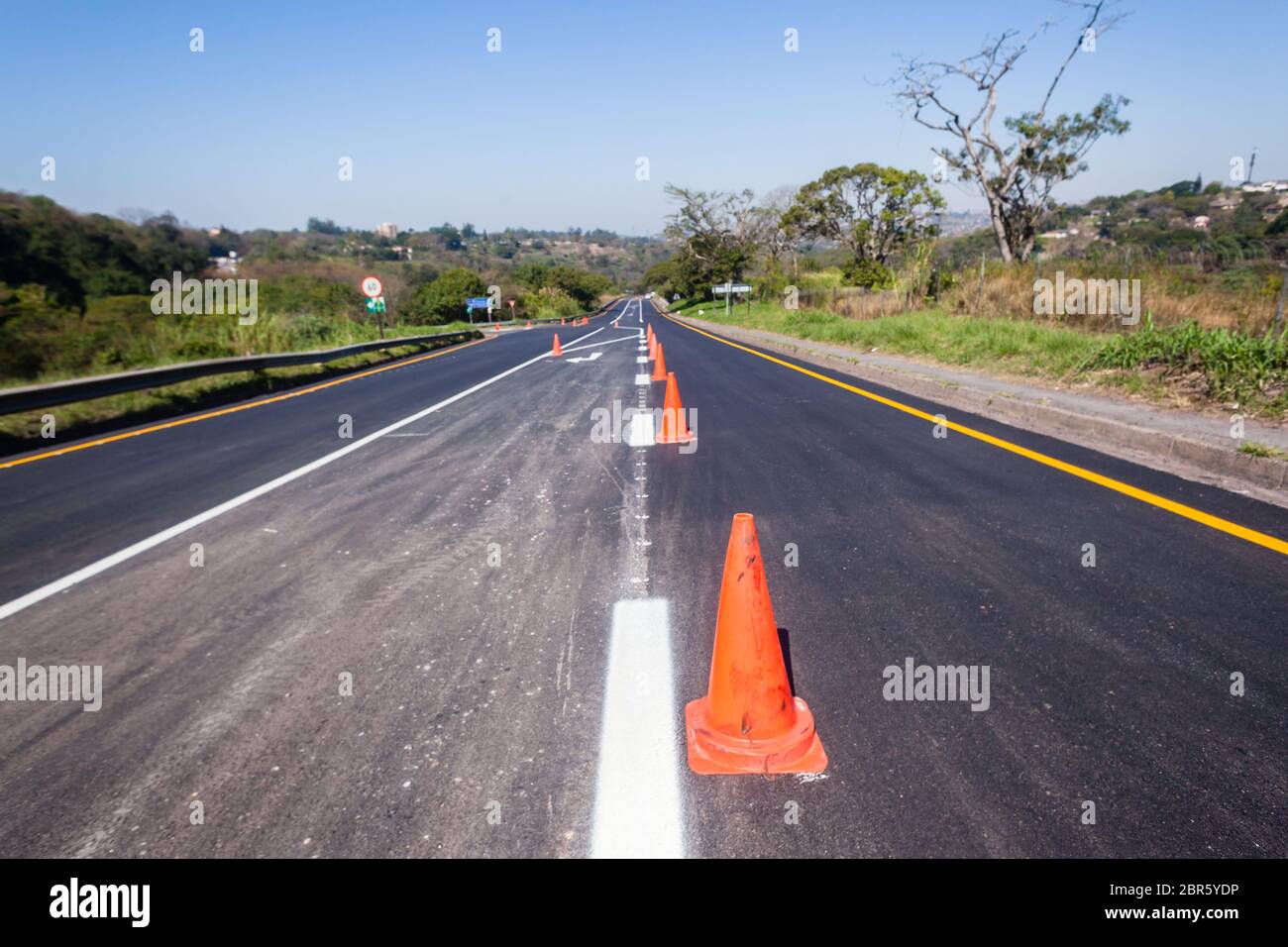 Road painting lines on new asphalt surface with orange markers Stock ...