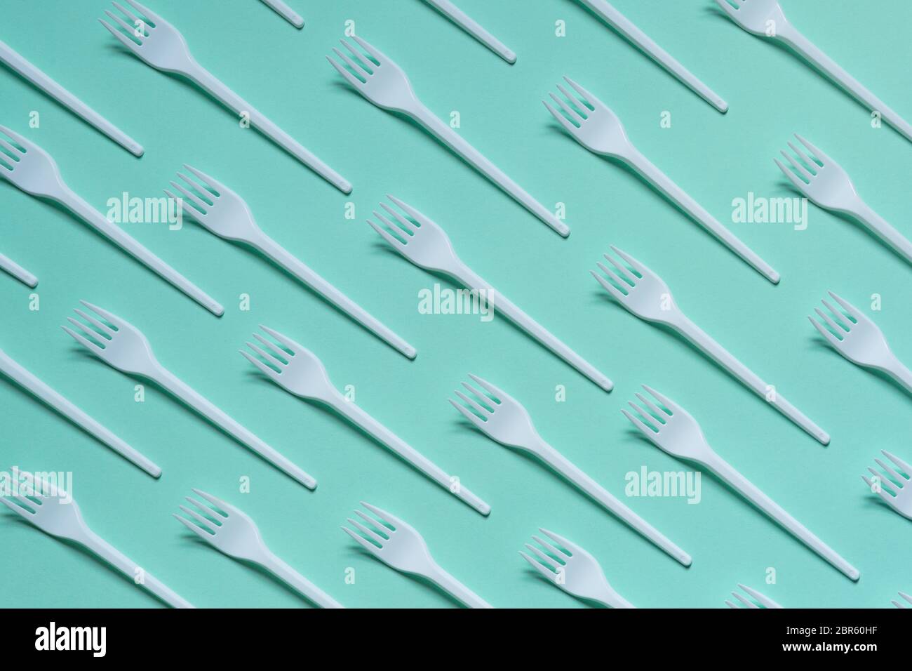 Plastic white forks on pastel blue background Stock Photo - Alamy