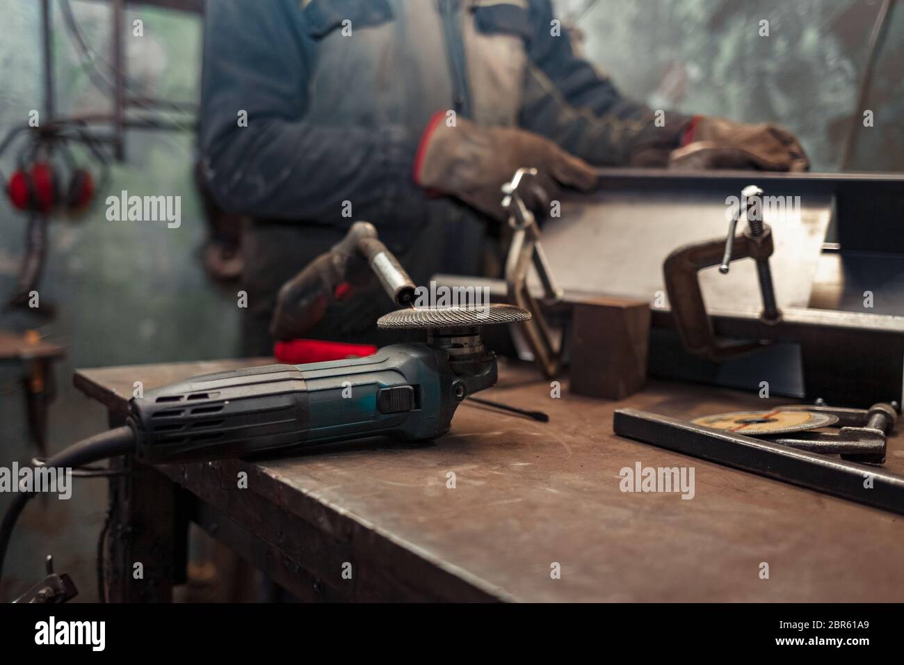 Man clamps iron products into c-clamps. Man works with clamps. Steel ...