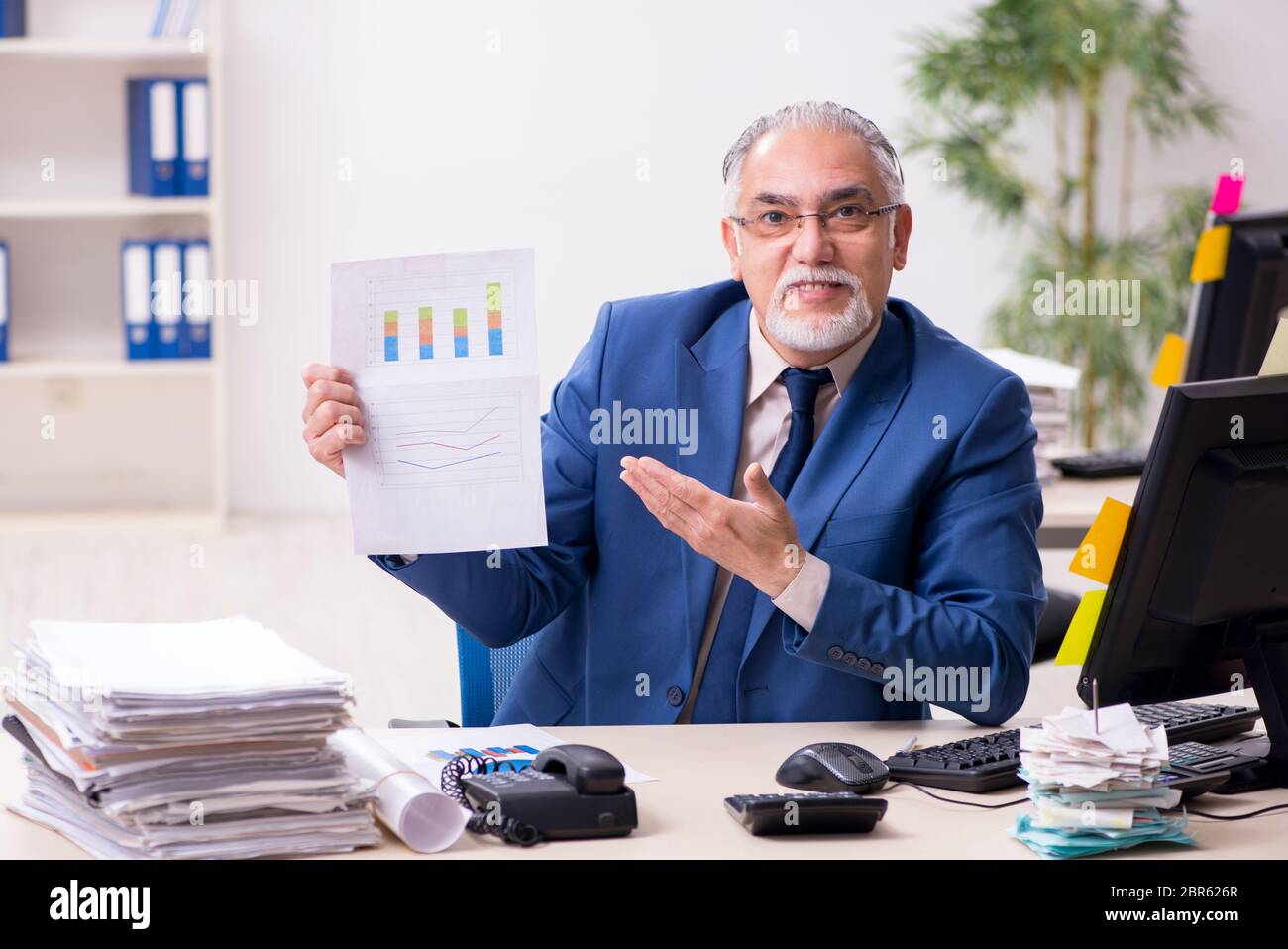 Old sales analyst working in the office Stock Photo - Alamy