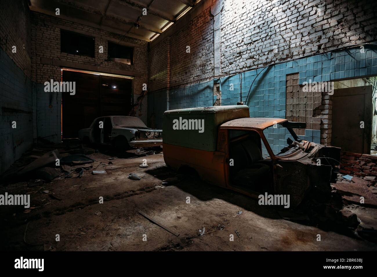 Old broken rusty cars inside abandoned repair garage Stock Photo - Alamy