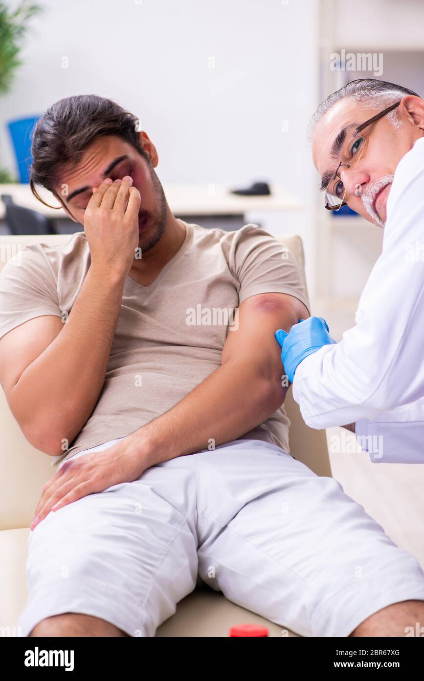 Young face injured man visiting experienced male doctor traumatologist ...