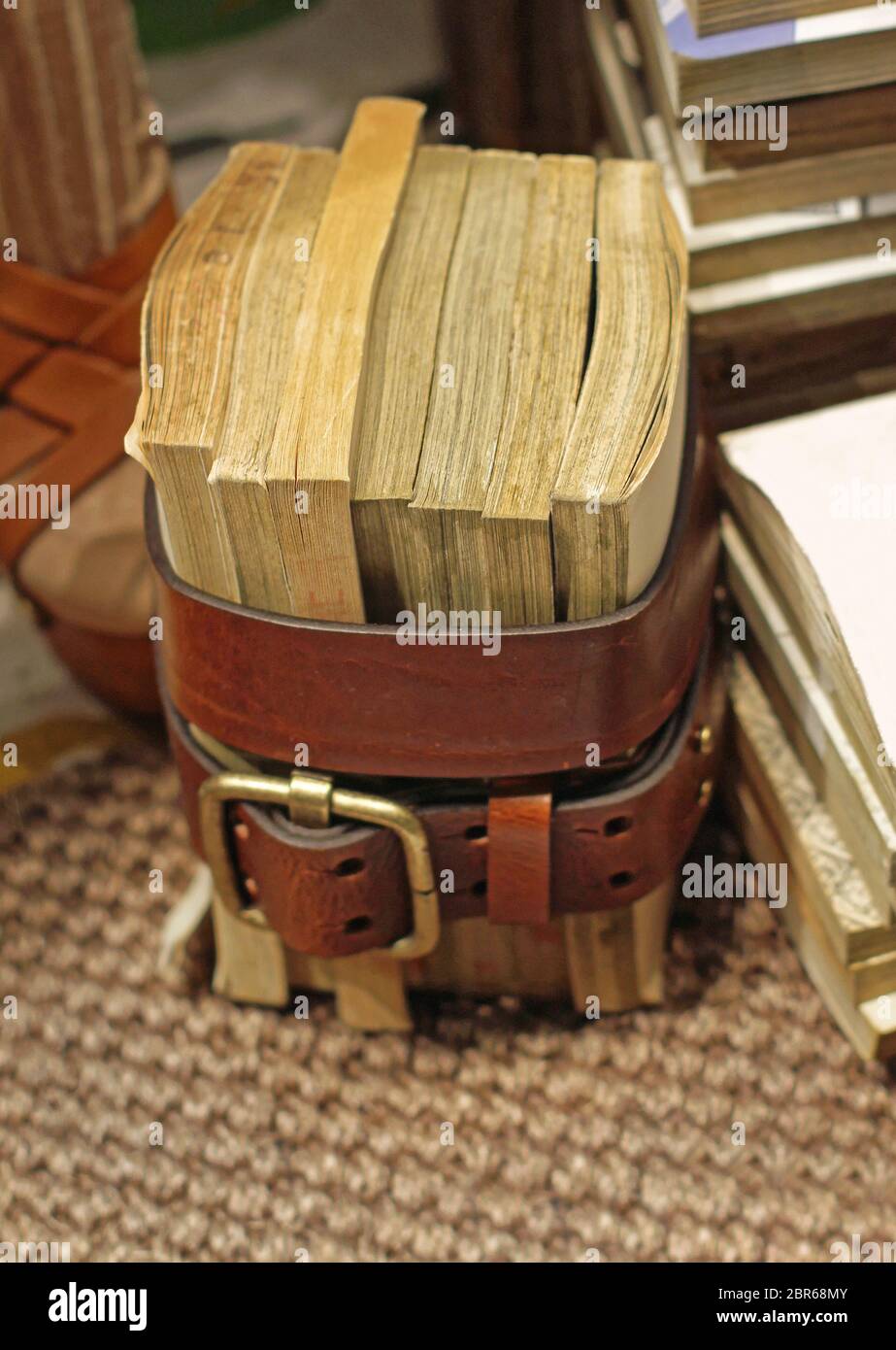 Old School Books Holding by Leather Belt Stock Photo - Alamy