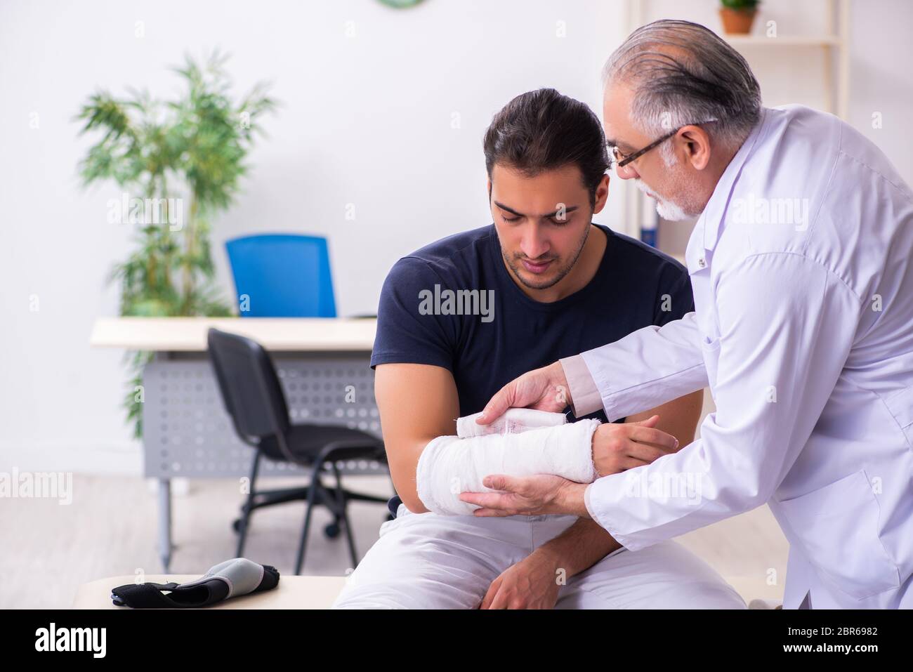 Young injured man visiting experienced doctor traumatologist Stock ...