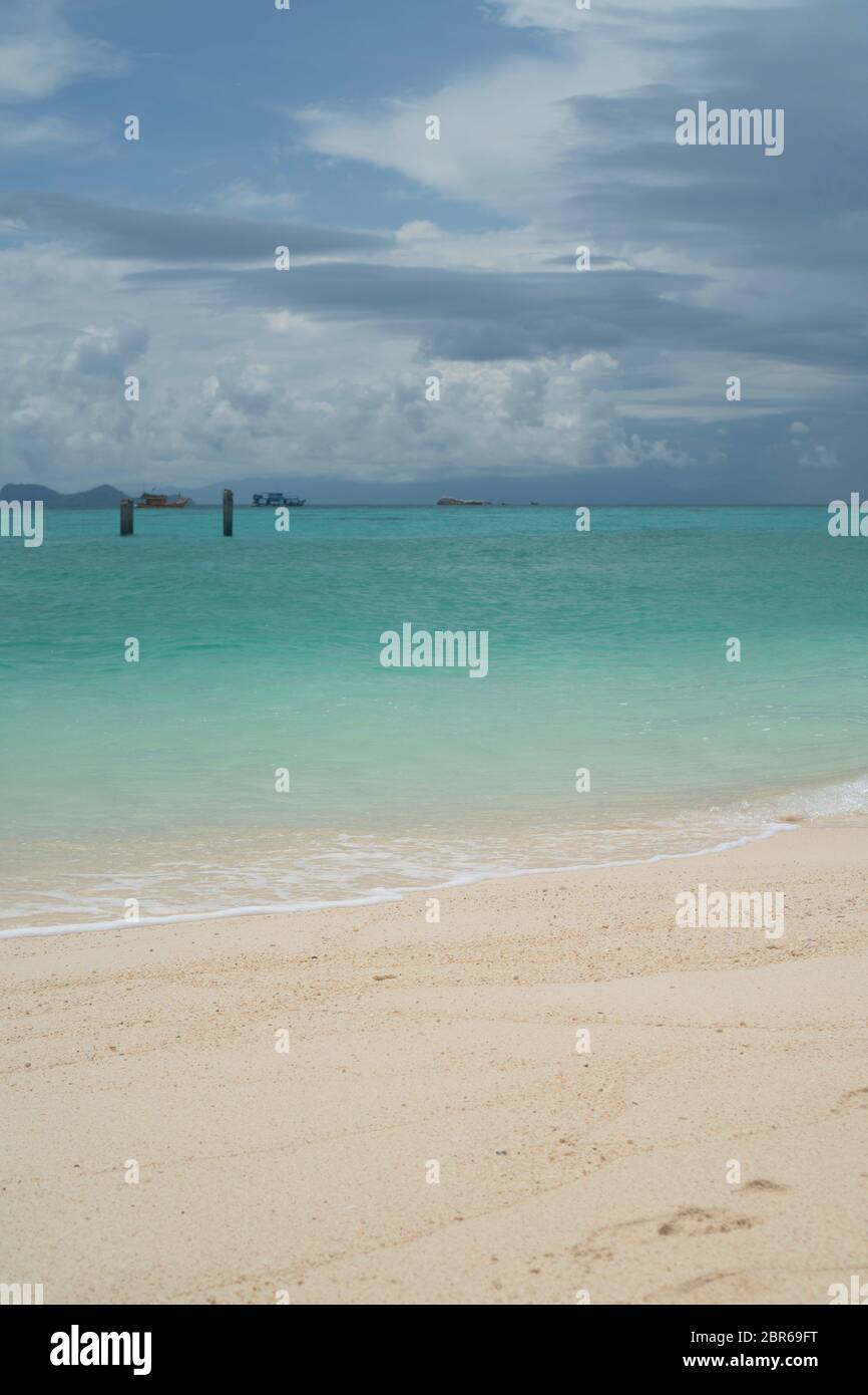 View from the beach on wooden piles in crystal clear sea water over ...