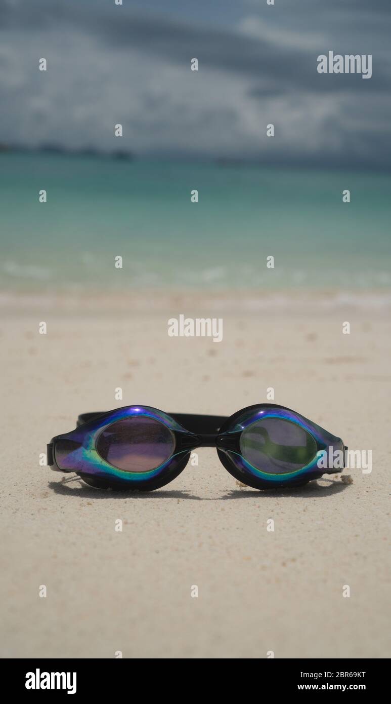 Swim goggles on sandy beach over lagoon sea background. Travel, holiday ...