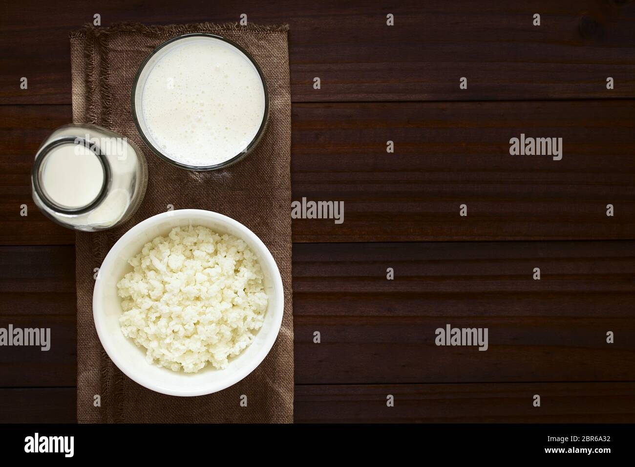Kefir grains in bowl, fresh kefir drink in glass and a bottle of milk ...