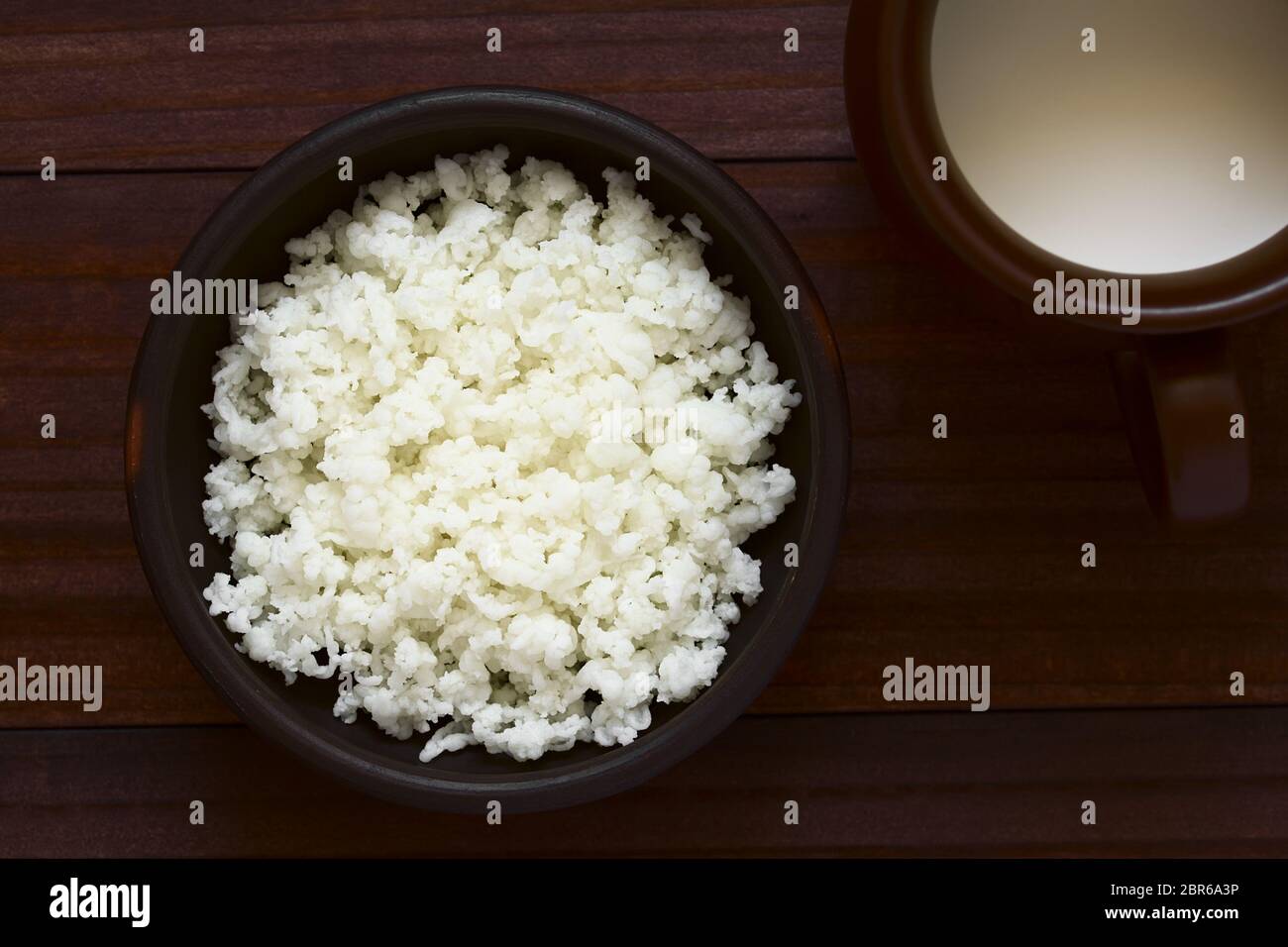 Kefir grains in bowl and a cup of milk on the side, photographed ...