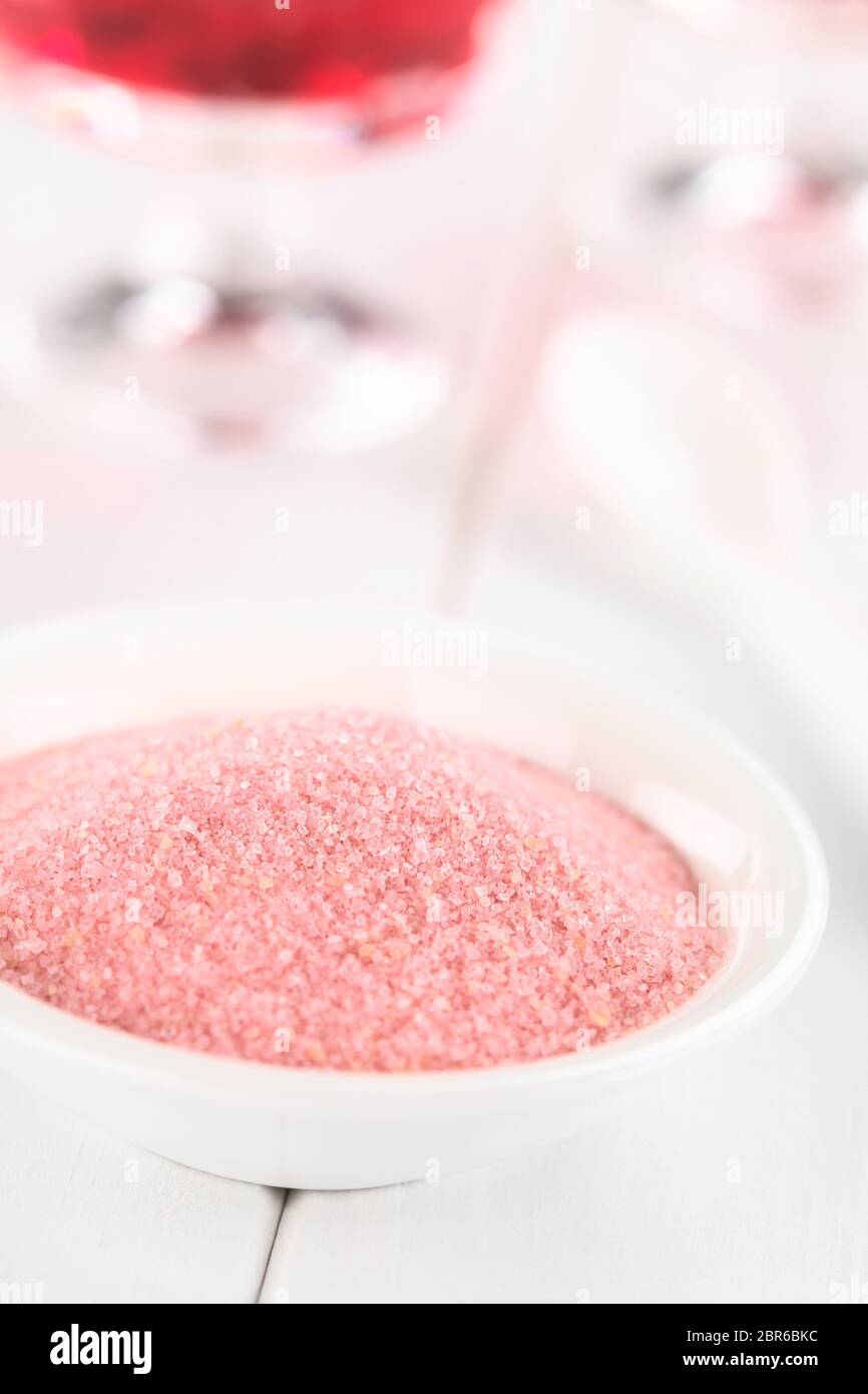 Red jelly or jello powder in small bowl, prepared jelly dessert and ...