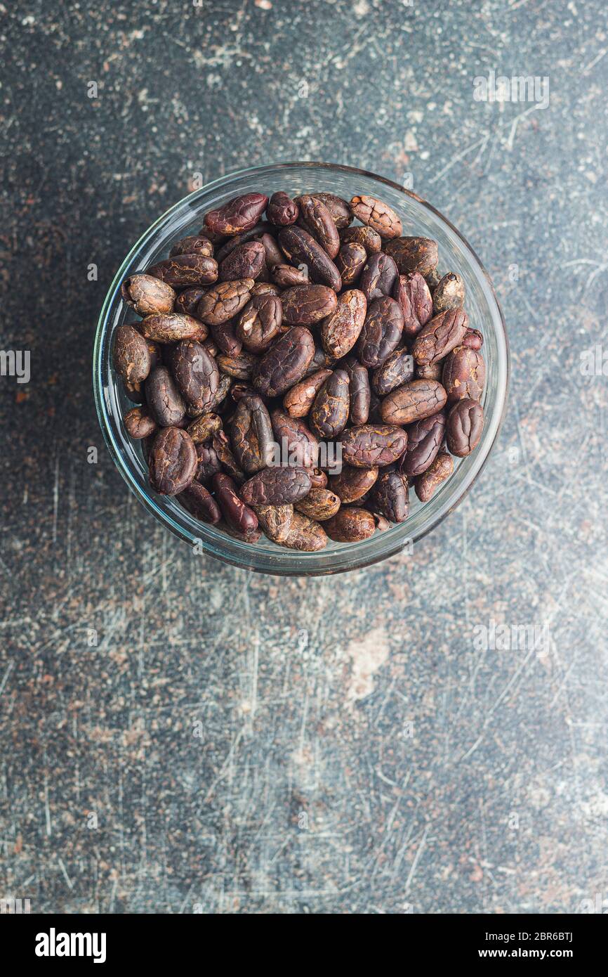 Dark cocoa beans in bowl Stock Photo - Alamy