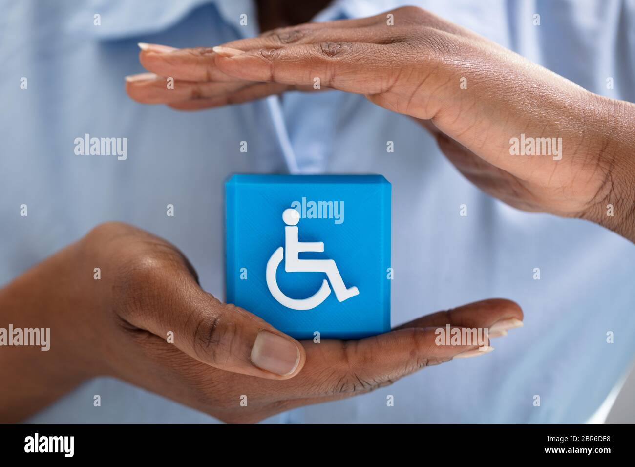 Close-up Of A Human's Hand Protecting Blue Cubic Block With Disabled ...