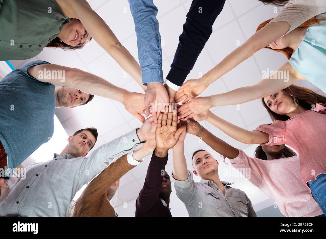 Diverse group smiling stacking hands hi-res stock photography and ...