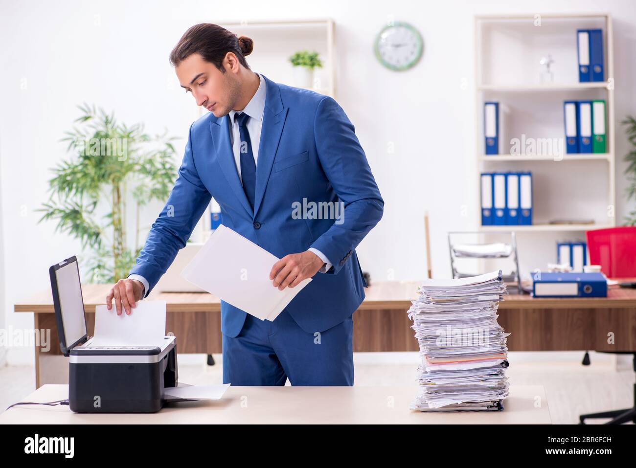 Young employee making copies at copying machine Stock Photo - Alamy