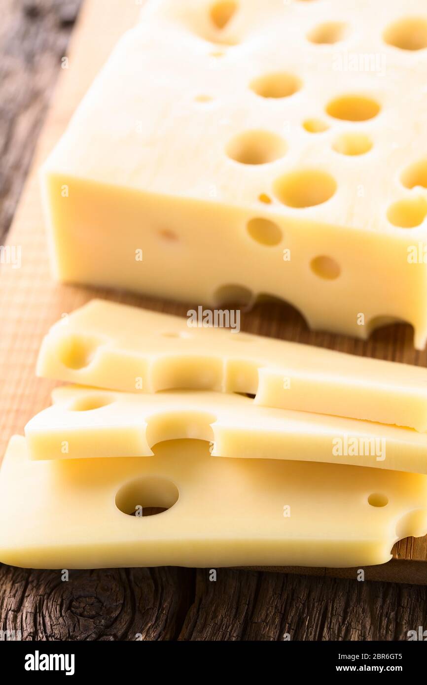 Piece and slices of Emmental, Emmentaler or Emmenthal cheese on wooden ...