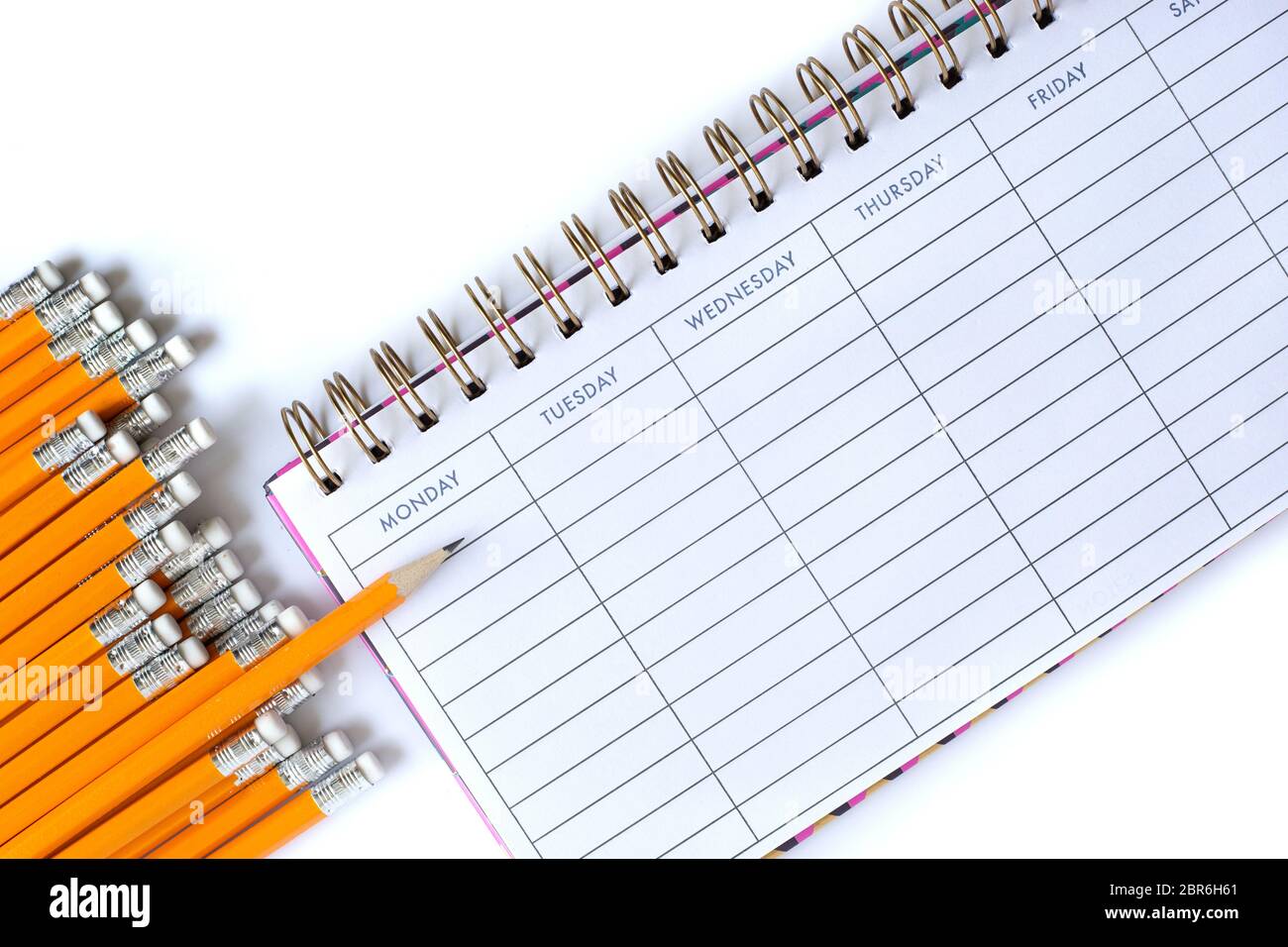 Stationery flat lay. Weekly organizer planner, sharp pencil surrounded ...