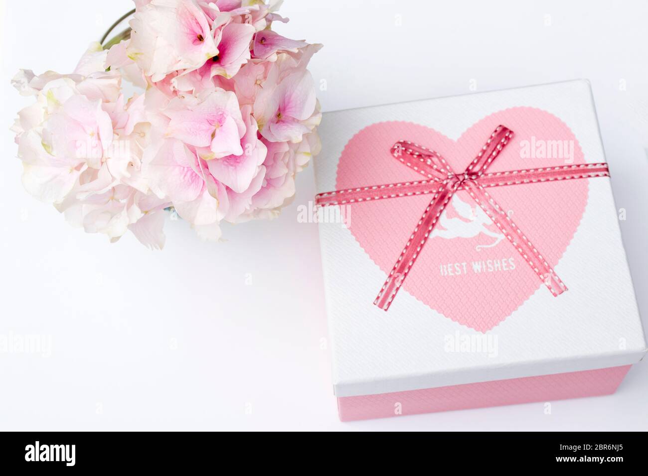 Ball-shaped pink hydrangea in a round glass vase with box for heart ...