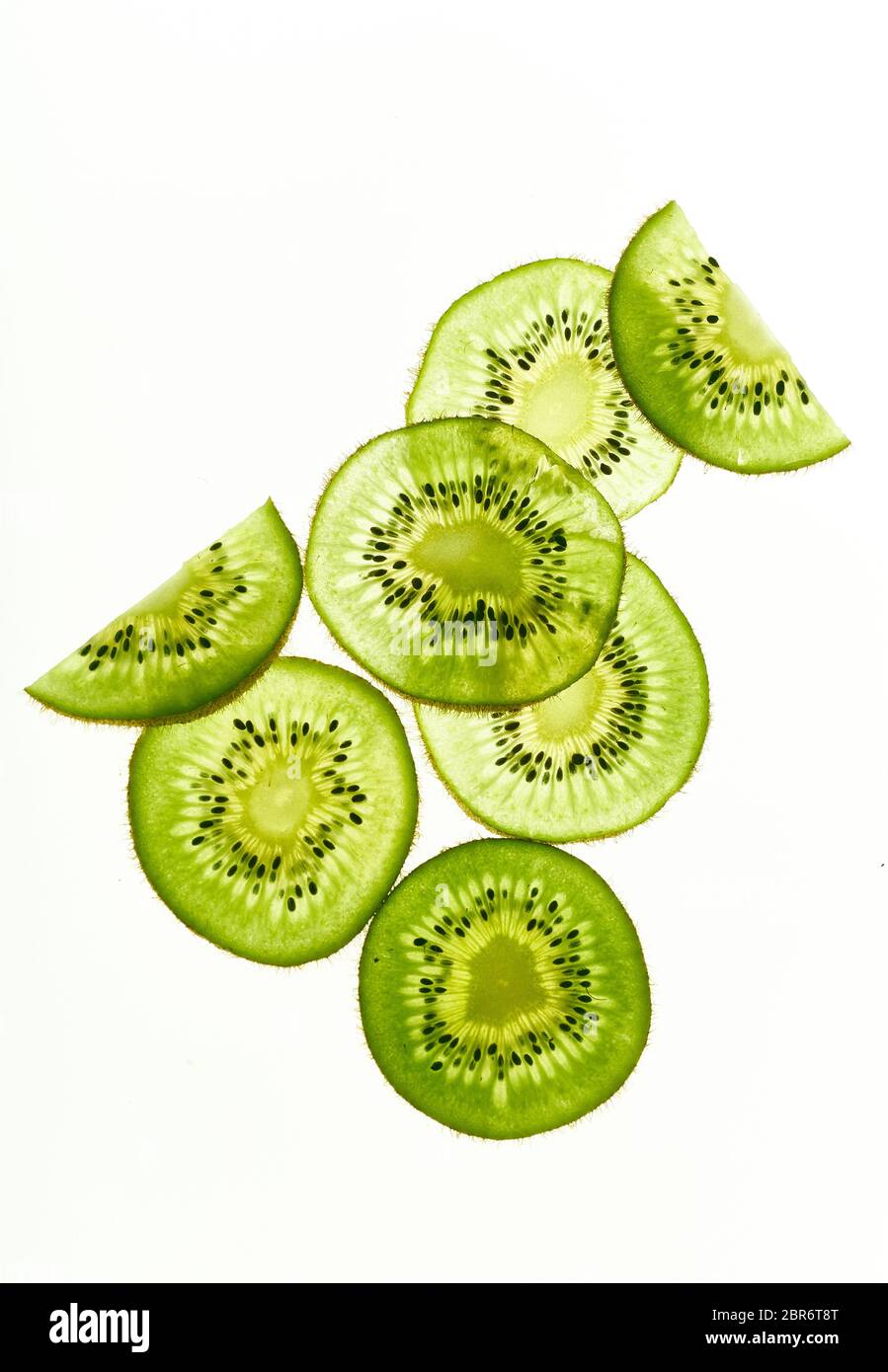 Backlit kiwi fruit slices on white background. Top view layout Stock ...