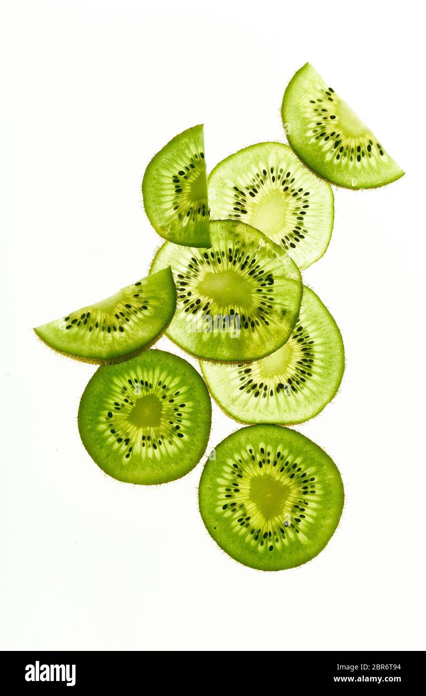 Backlit kiwi fruit slices on white background. Top view layout Stock ...