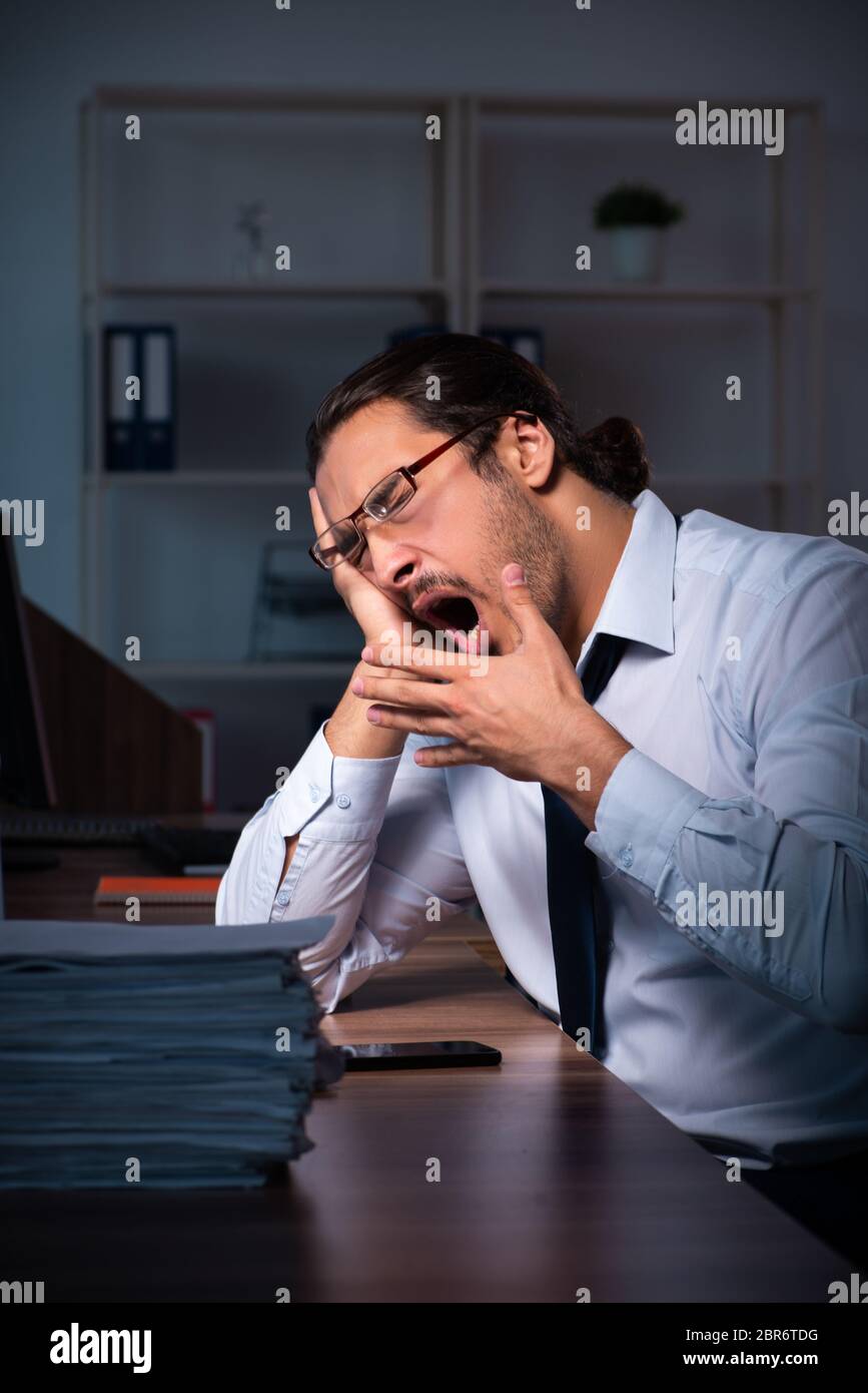 Young employee working in the office night time Stock Photo - Alamy