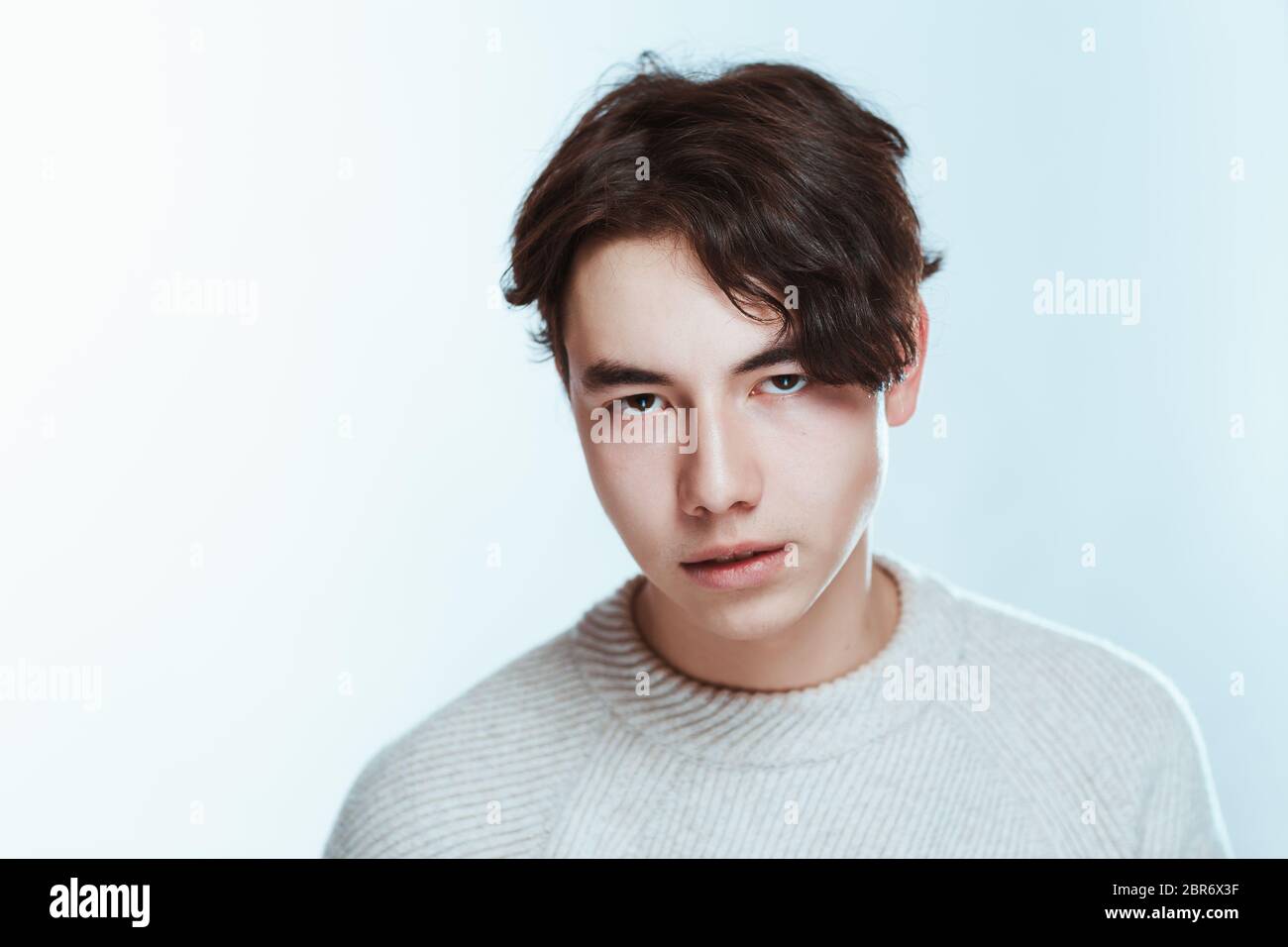 portrait of a teenager brunette guy in a studio Stock Photo - Alamy