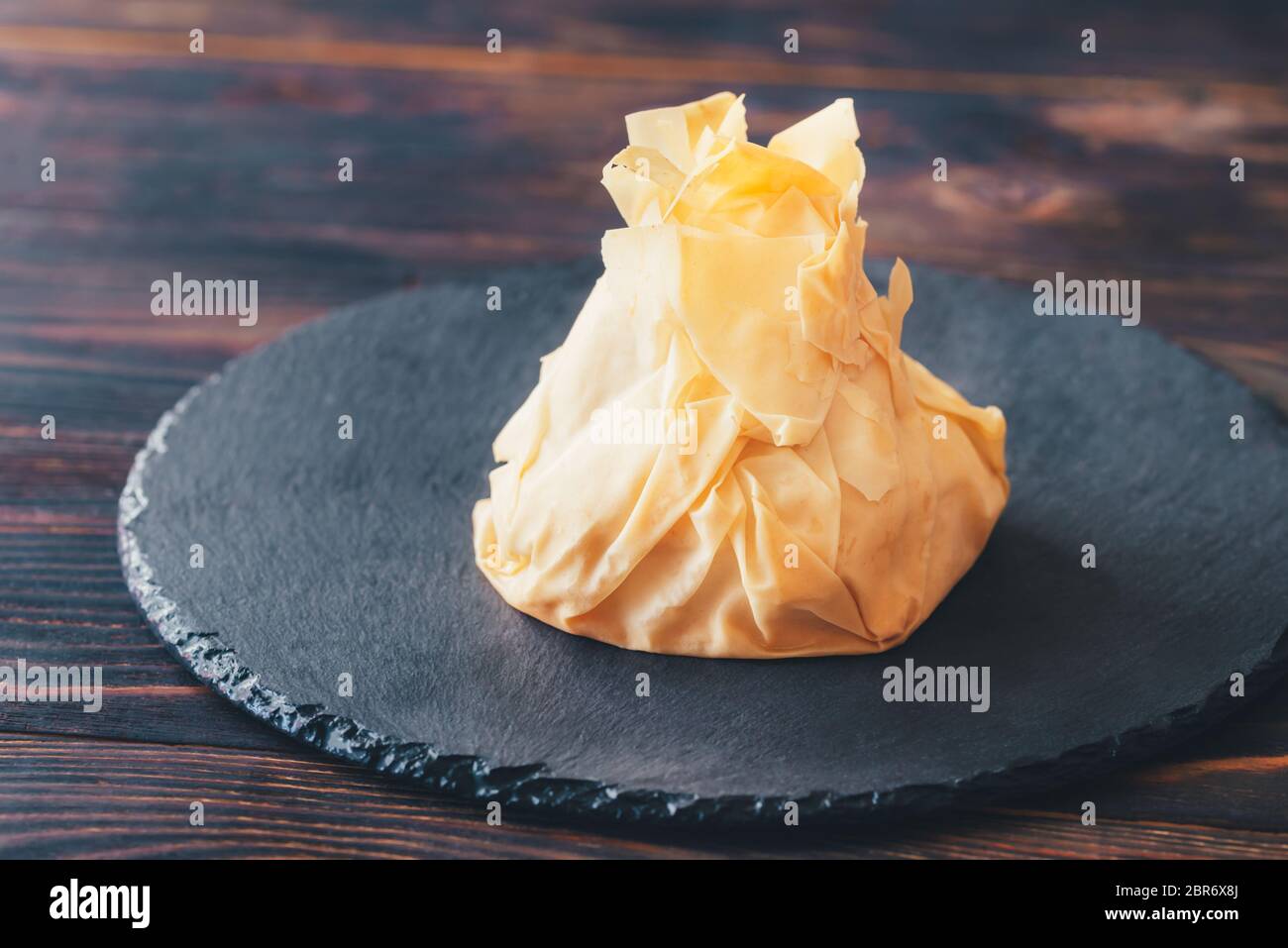 Baked Camembert in phyllo pastry on the black stone board Stock Photo ...