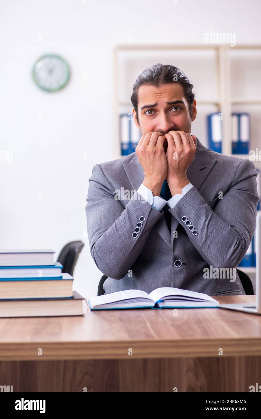 Young businessman reading books at workplace Stock Photo - Alamy